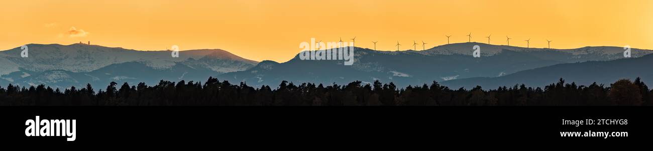 Styrian alps covered with snow in orange light of sunset. View at ...
