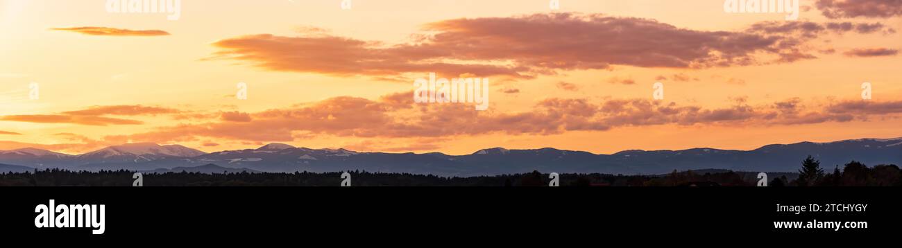 Styrian alps covered with snow in orange light of sunset. View at ...