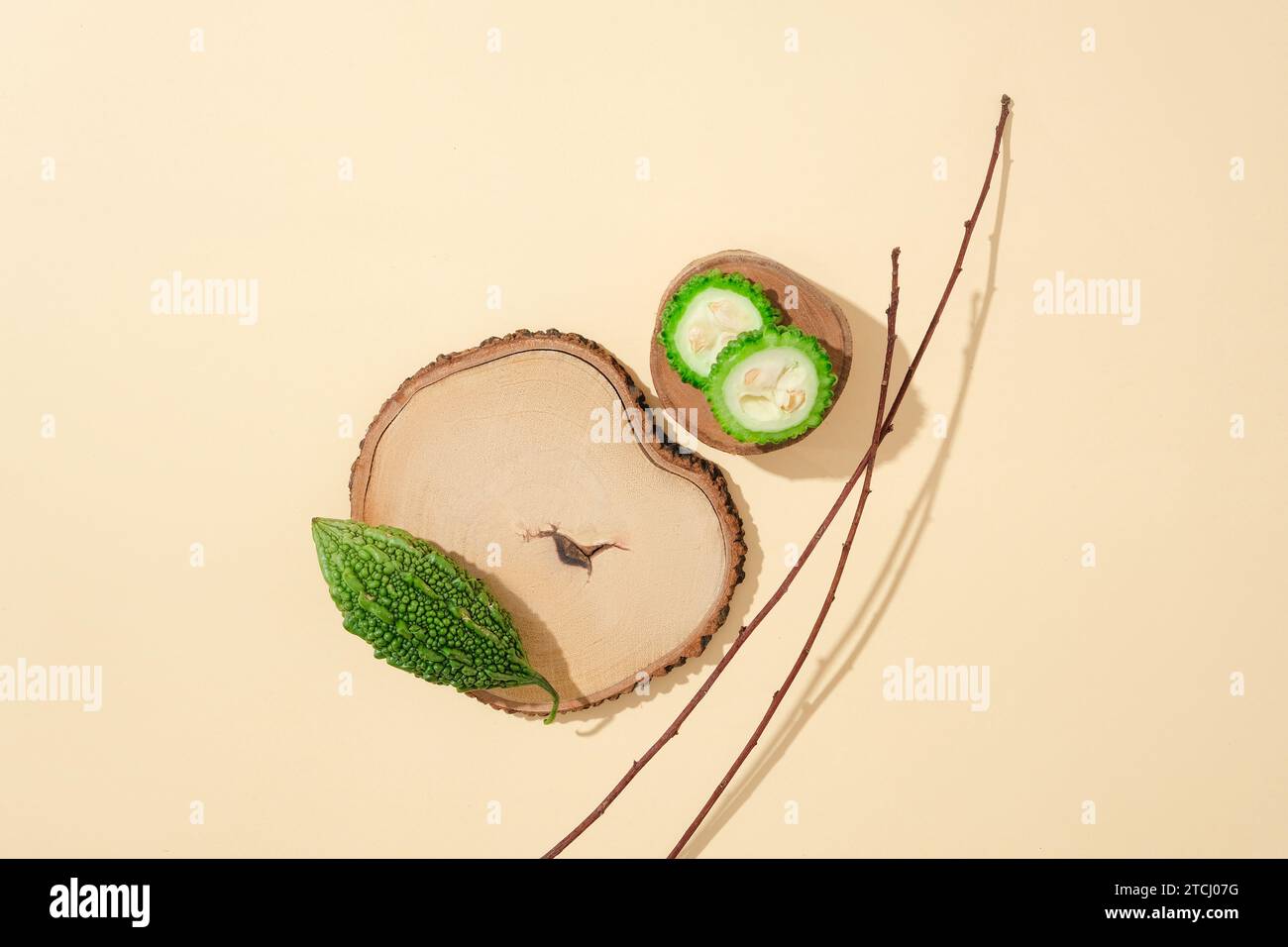 Two slices of bitter melon on a wooden platform, one bitter melon on a ...