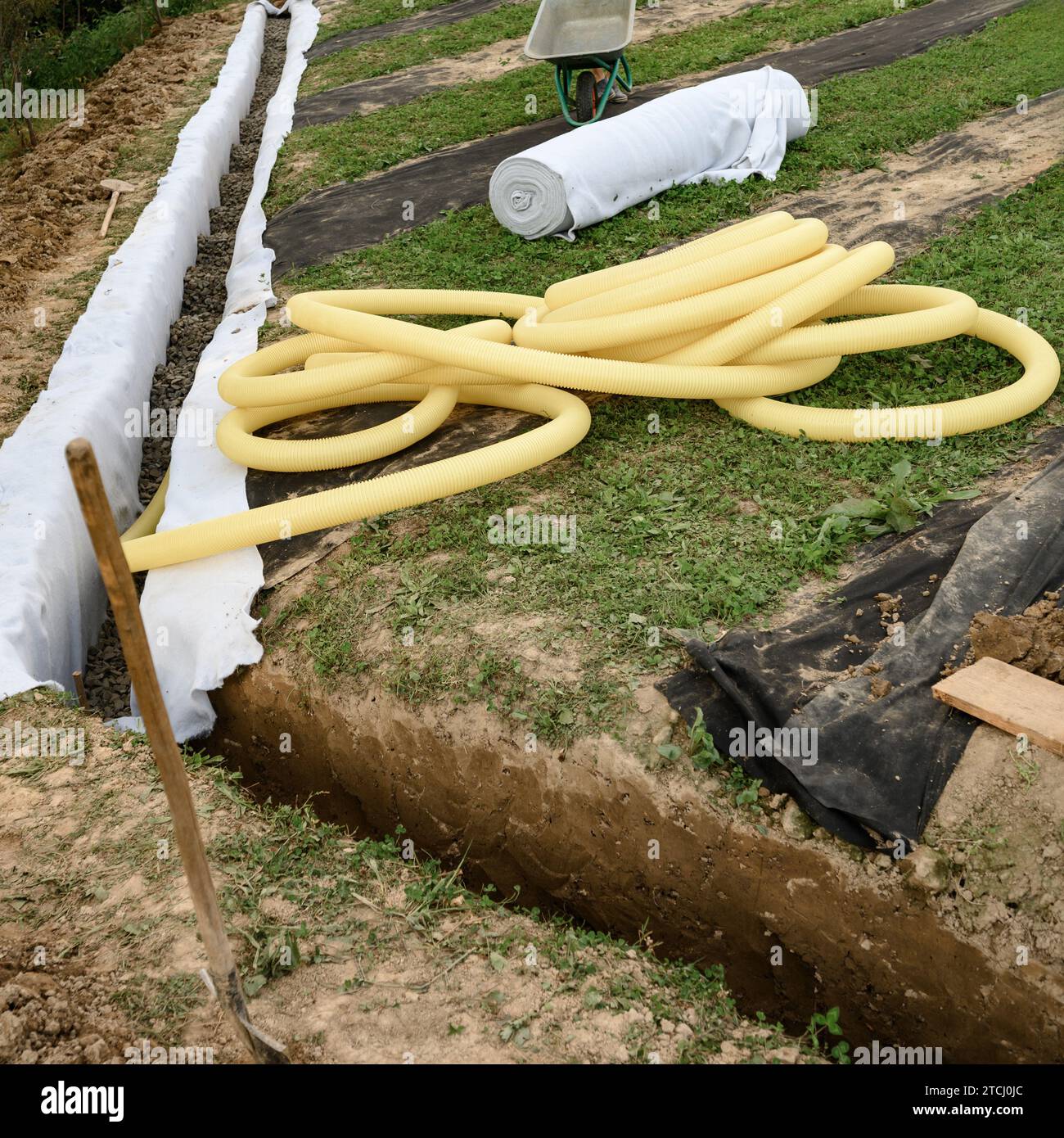 Yellow corrugated pipe with perforation in a trench with crushed stone ...