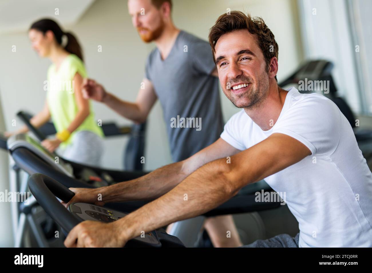 Group of young people doing exercises in gym to stay healthy. Sport gym ...