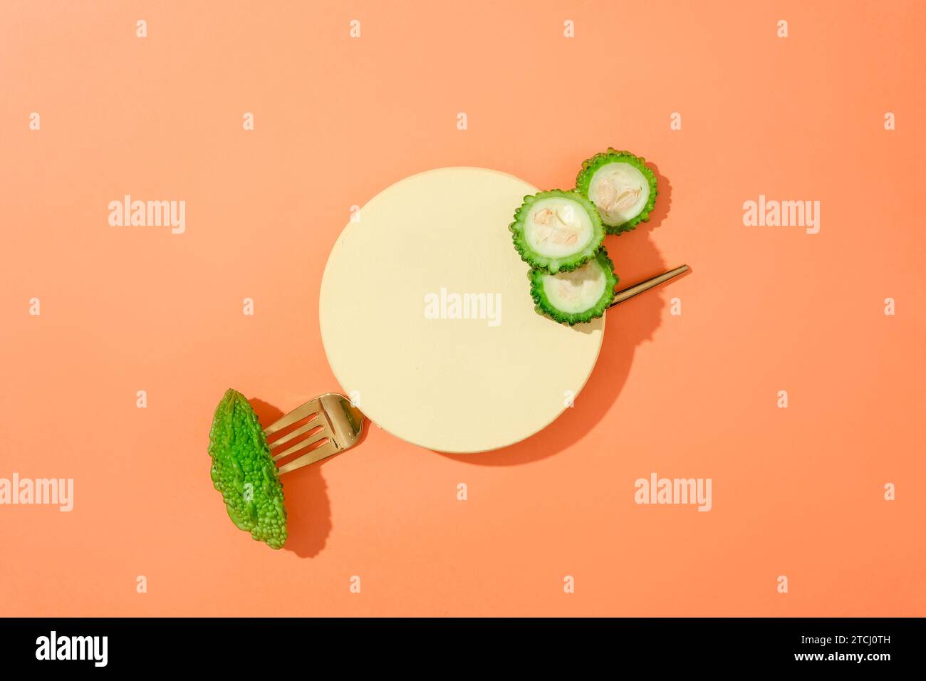 Metal fork inserted into bitter melon, a round platform and three ...