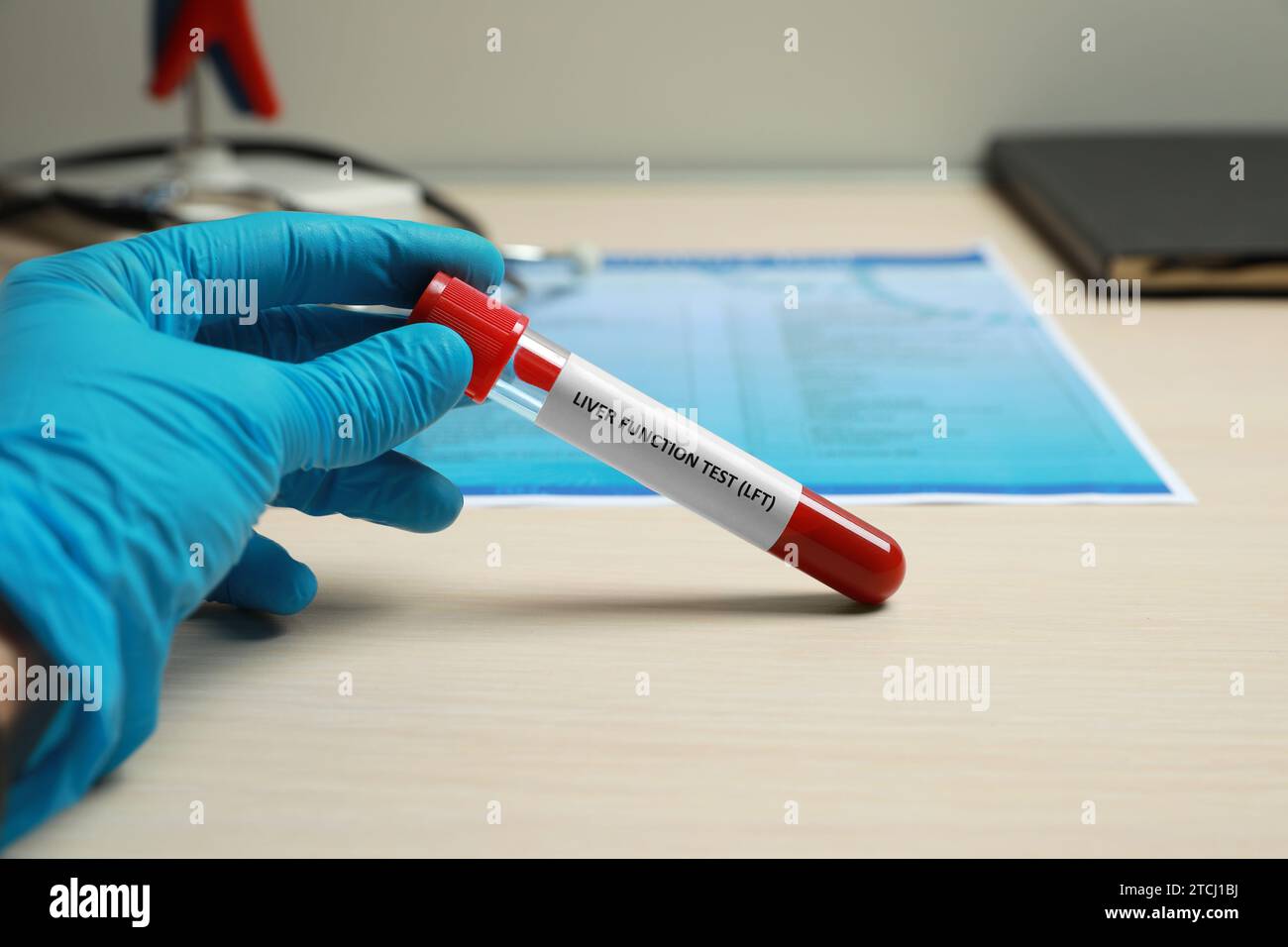 Laboratory worker holding tube with blood sample and label Liver ...