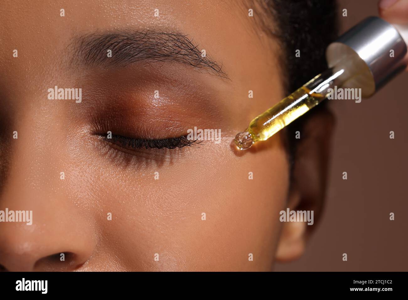 Woman applying serum onto her face, closeup Stock Photo - Alamy