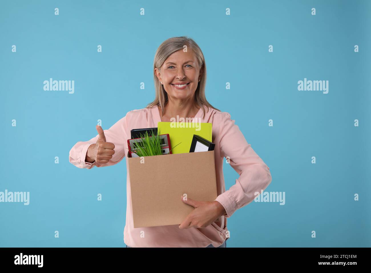 Happy unemployed senior woman with box of personal office belongings ...