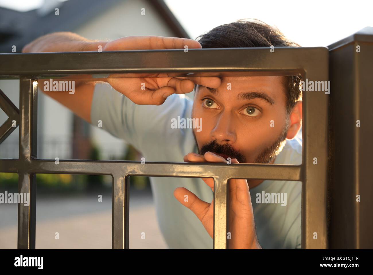 Concept of private life. Curious man spying on neighbours over fence ...