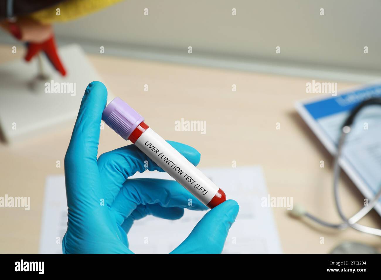 Laboratory worker holding tube with blood sample and label Liver ...
