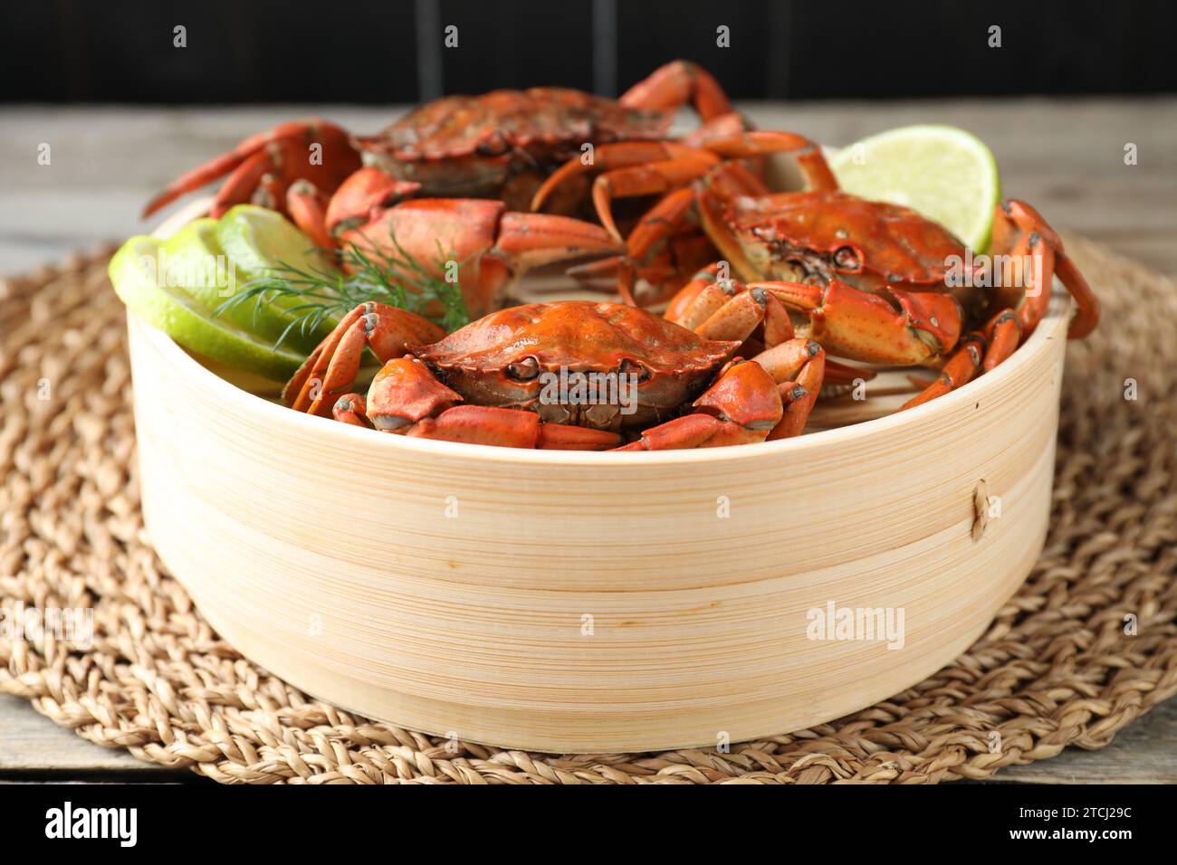 Delicious boiled crabs with lime and dill in bamboo steamer on table, closeup Stock Photo - Alamy
