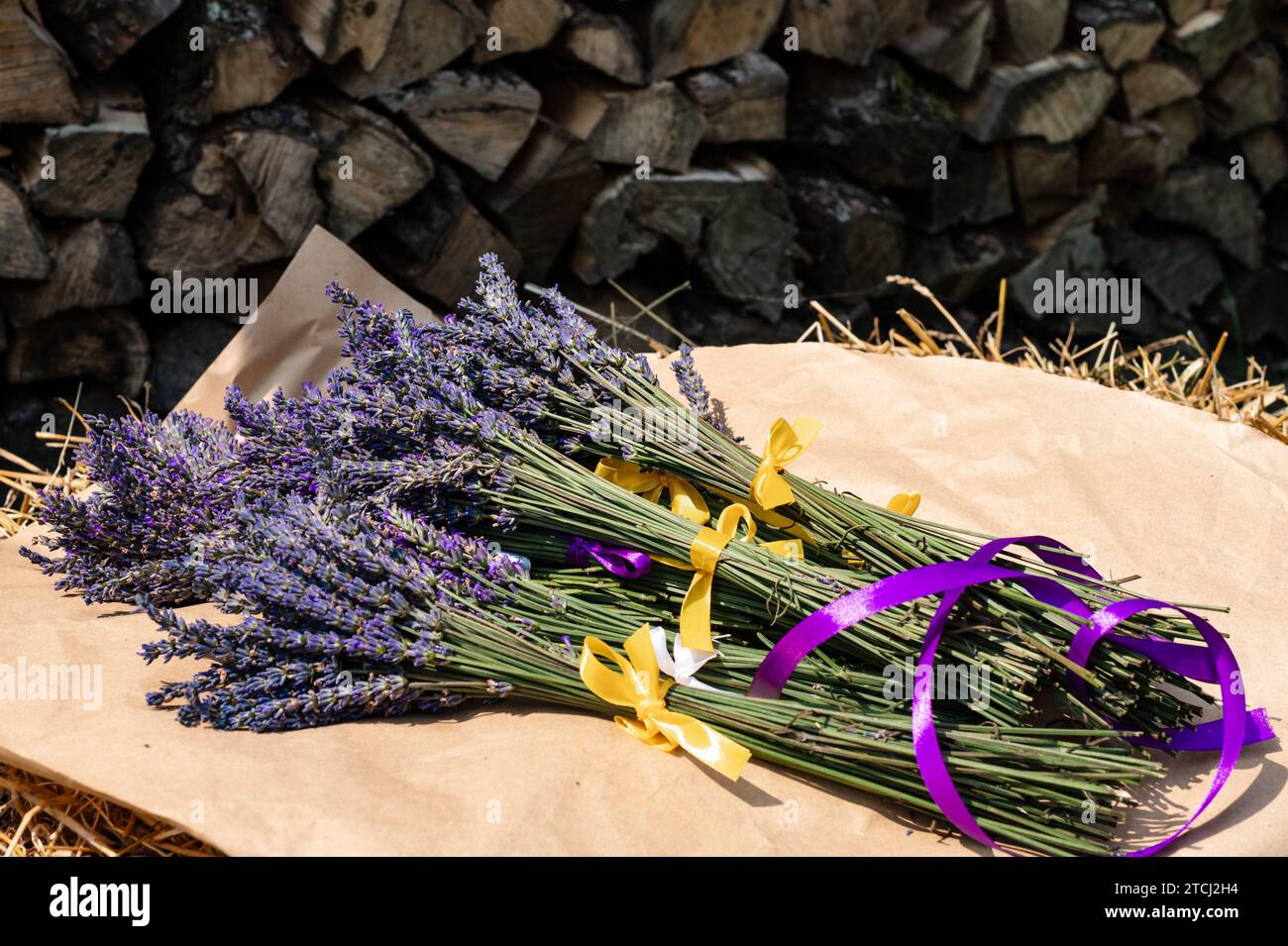 Lavender bouquets with purple and yellow ribbons lie on kraft paper ...