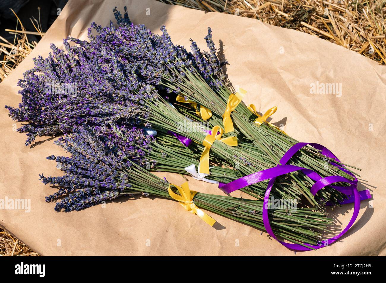 Lavender bouquets with purple and yellow ribbons lie on kraft paper ...