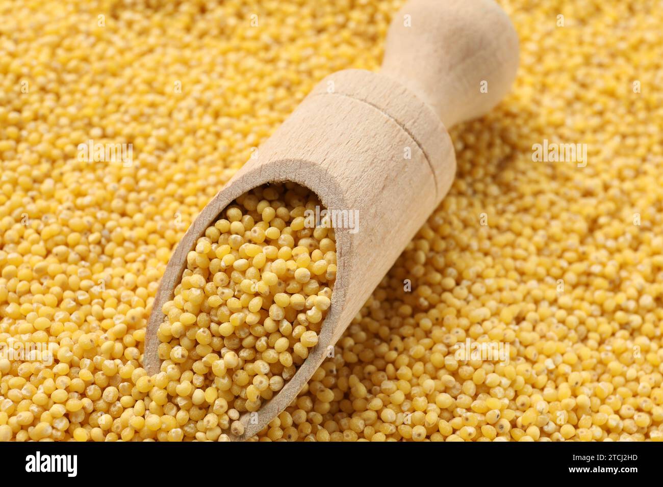 Wooden scoop with dry millet seeds, closeup Stock Photo - Alamy