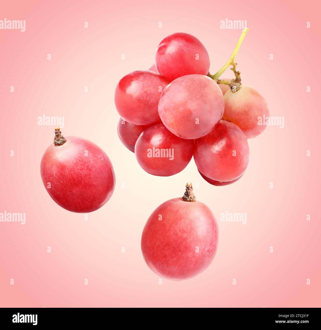 Many fresh grapes falling on pink background Stock Photo - Alamy