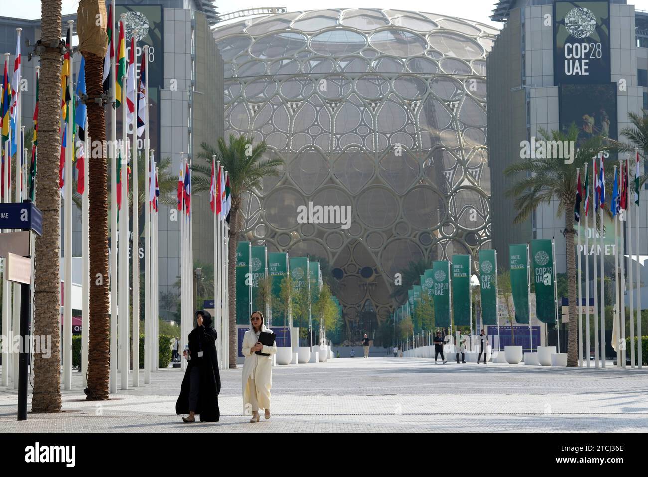 People walk through the COP28 U.N. Climate Summit, Wednesday, Dec. 13 ...
