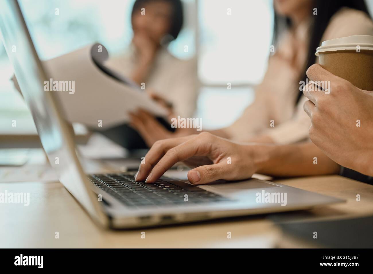 Close up female employee hand typing on laptop while sitting at meeting ...