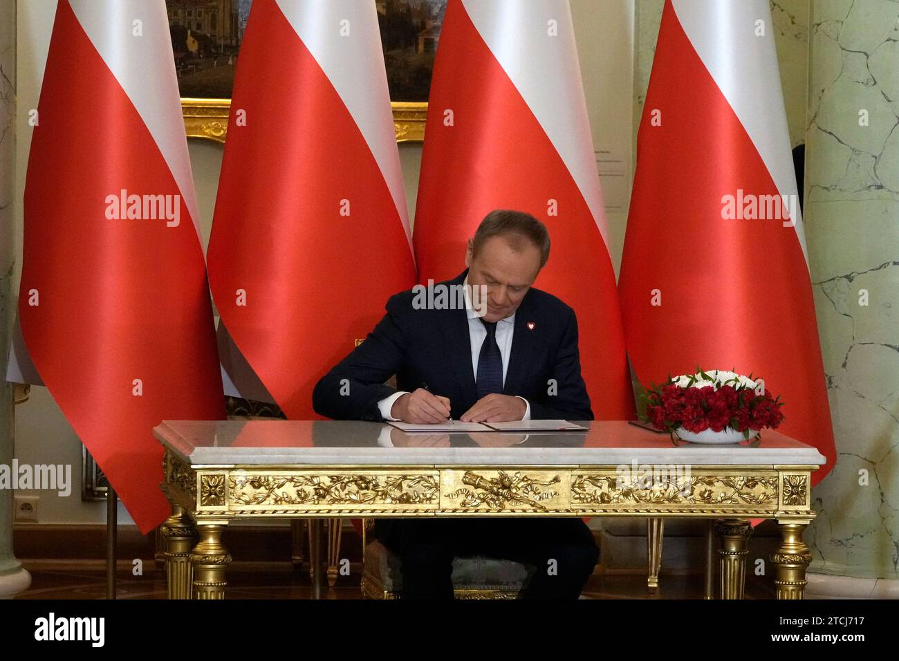 The new Polish Prime Minister Donald Tusk signs an oath at the presidential palace in Warsaw ...