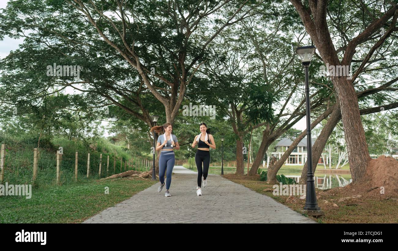 Two happy women going for sunrise running. Women in track suits running ...