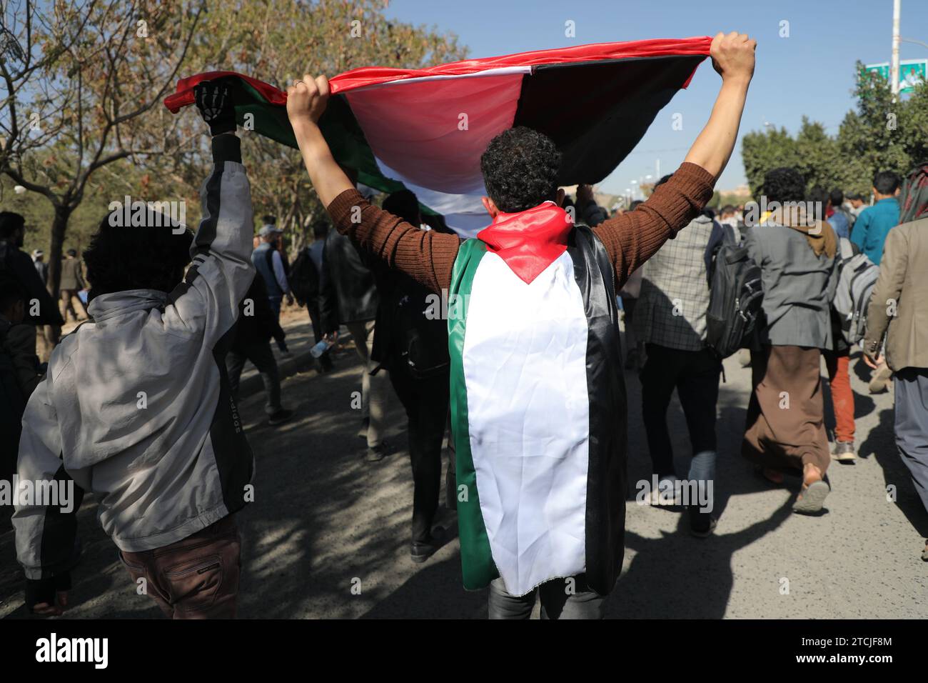 SANAA, Sanaa, Yemen. 13th Dec, 2023. Yemenis wave flags and chant ...