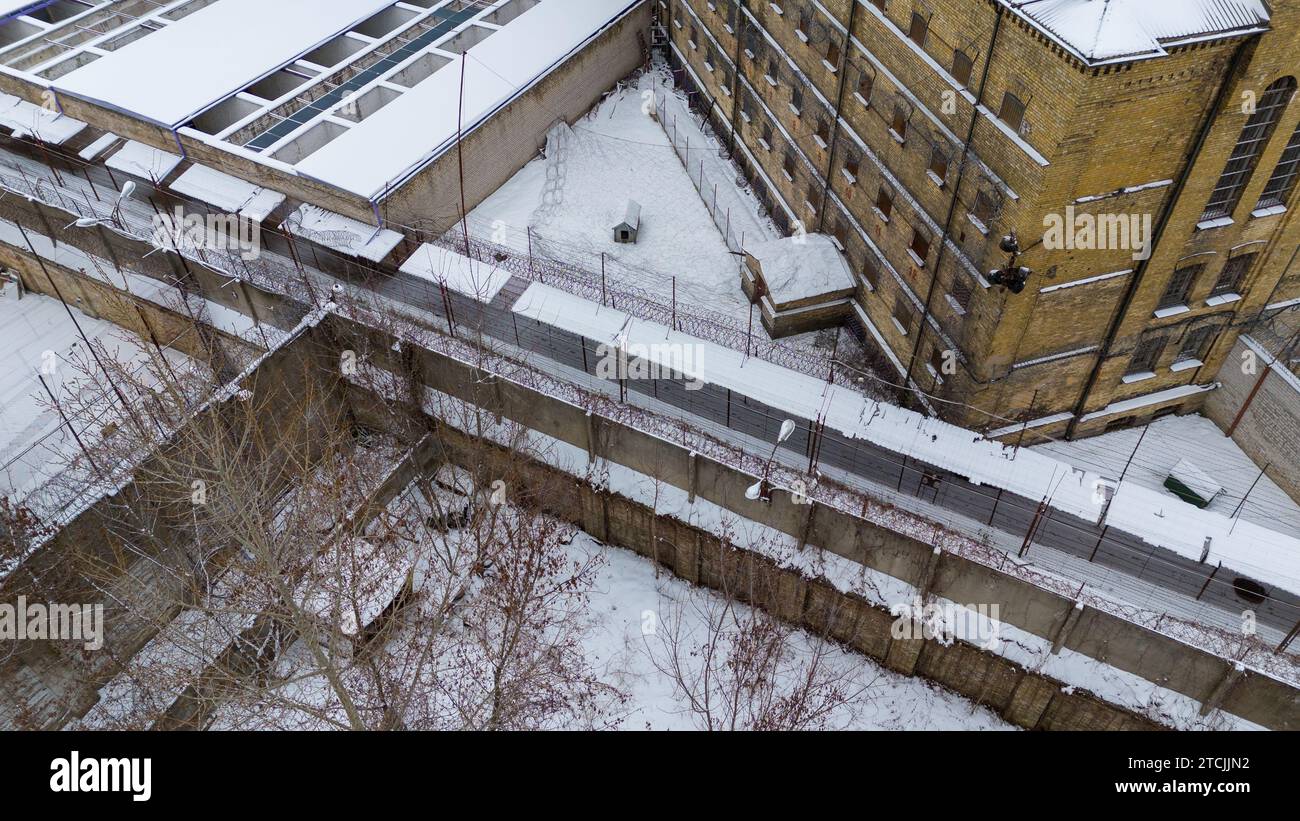 Drone photography of old prison metal and brick fence during winter day ...