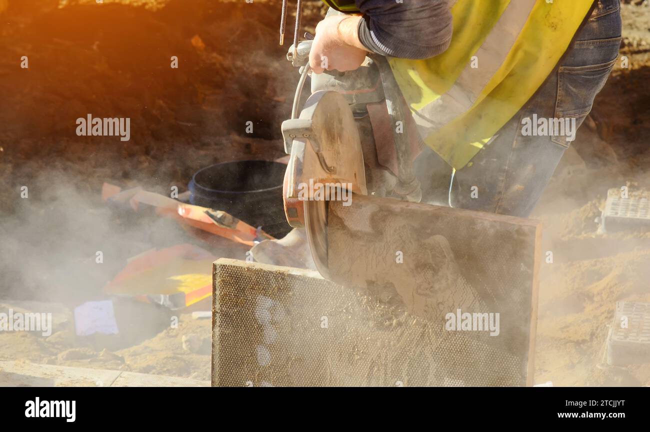 Builder cutting concrete slabs with petrol concrete saw and a diamond ...