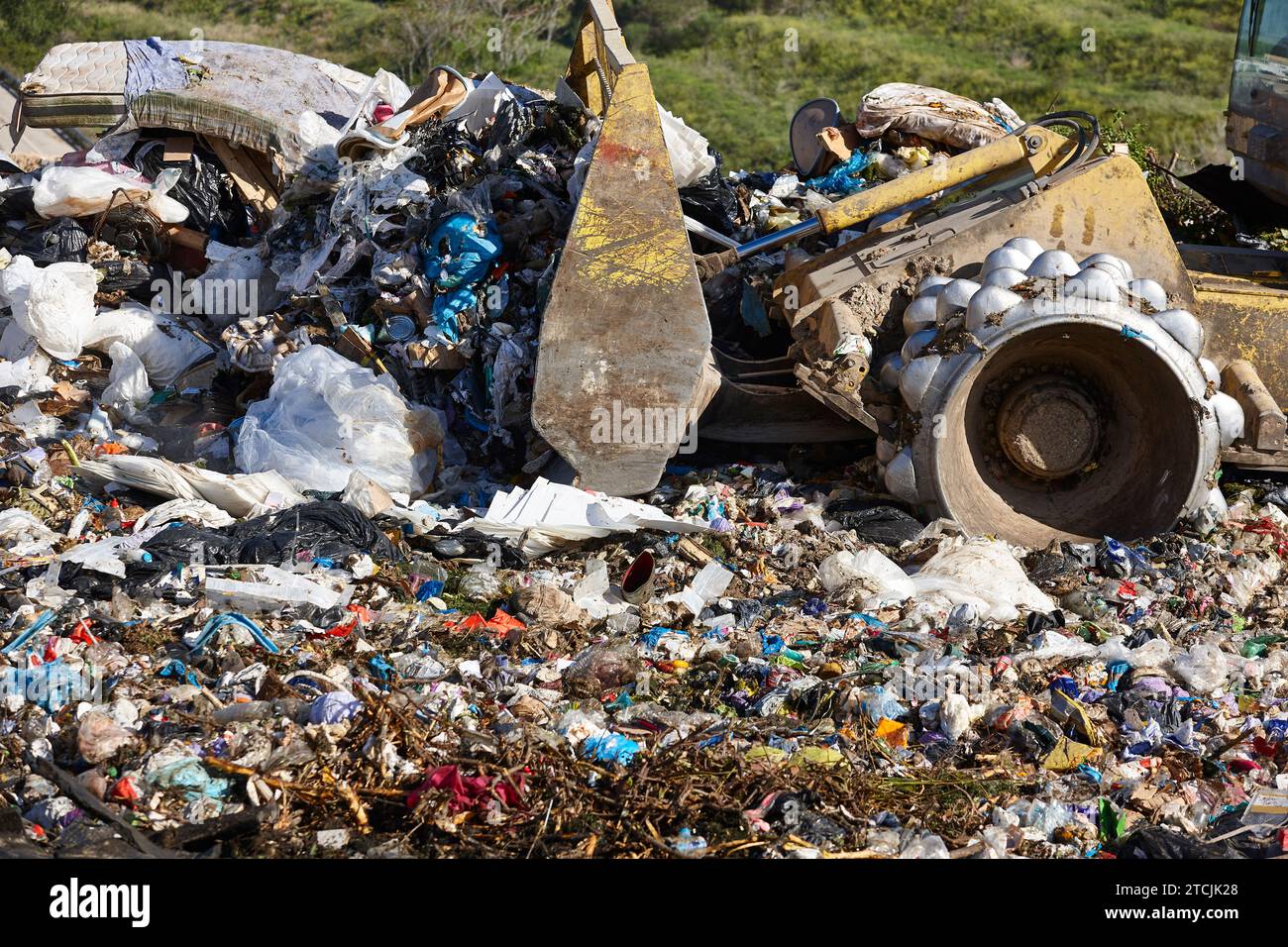 Heavy machinery shredding garbage in an open air landfill. Waste Stock ...