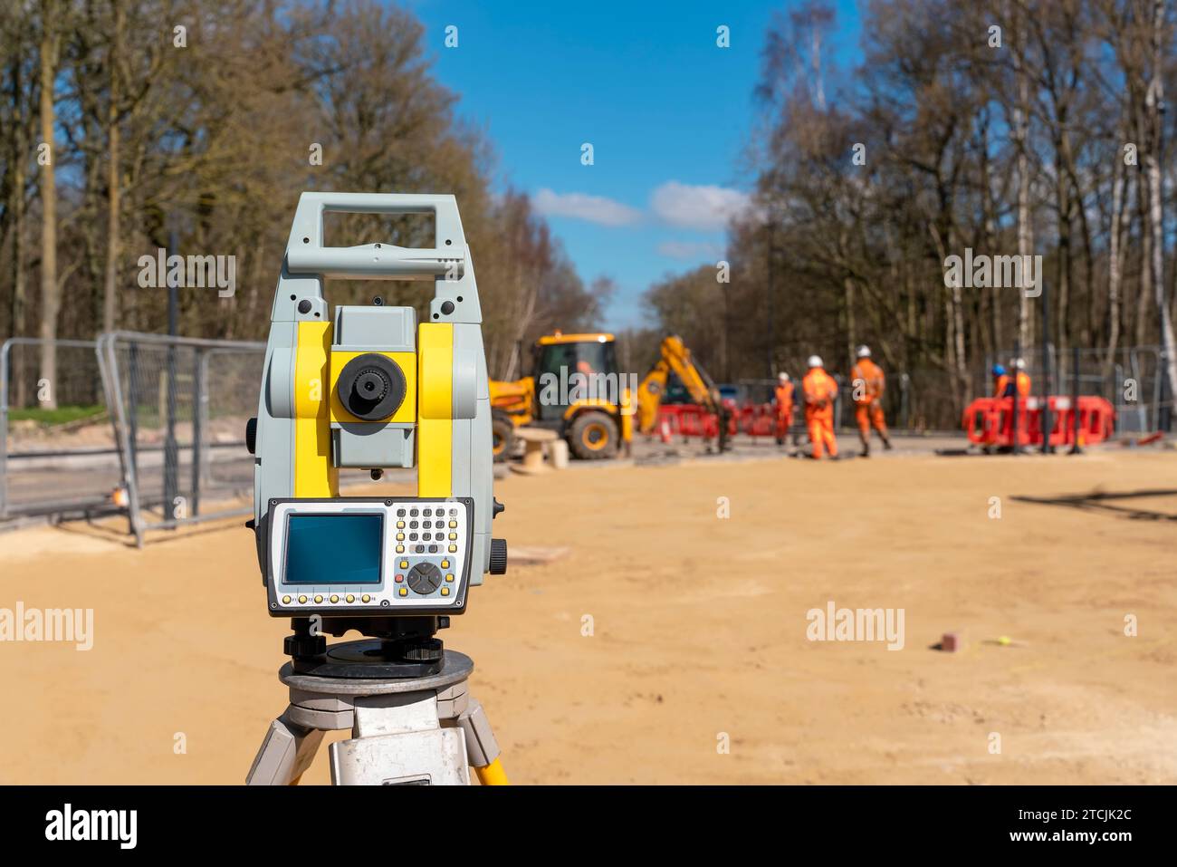 Yellow equipment set out on tripod on building site against cloudless ...
