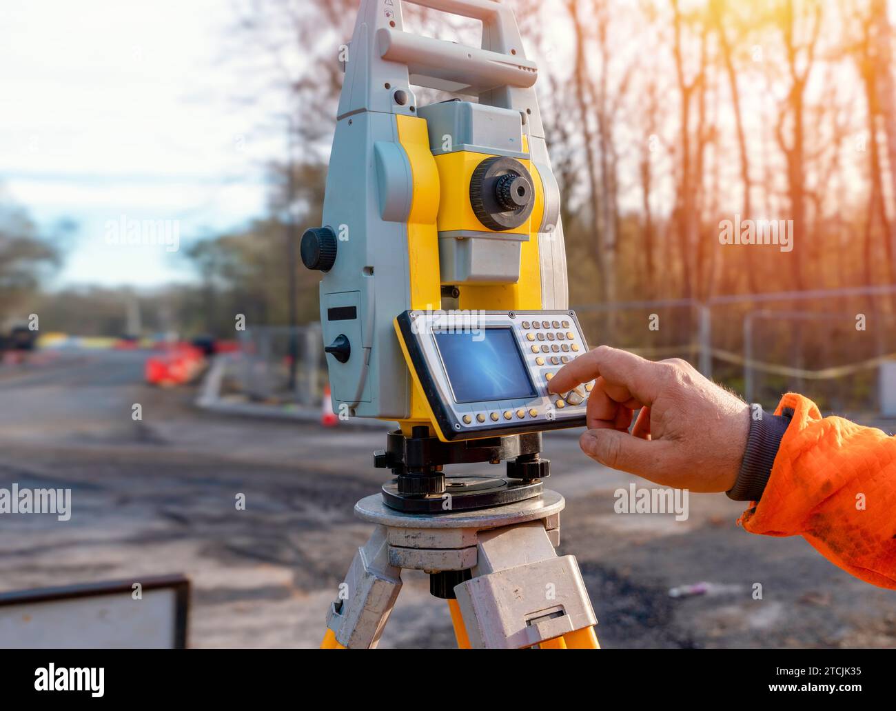 Site engineer operating his instrument during roadworks. Builder using ...