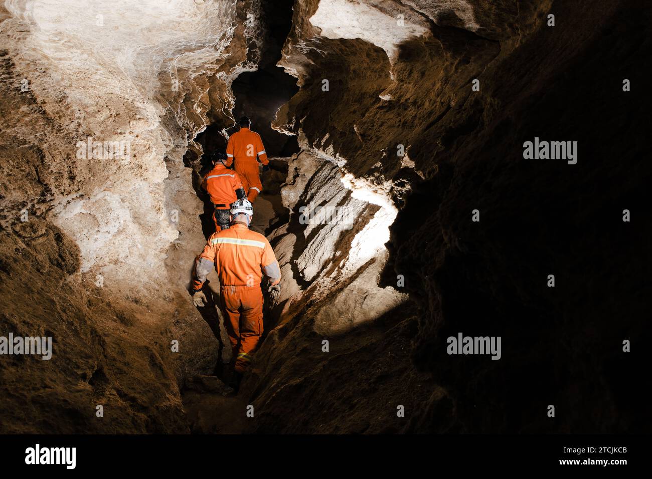 Three men, strong physique, explore the cave. Men dressed in special ...