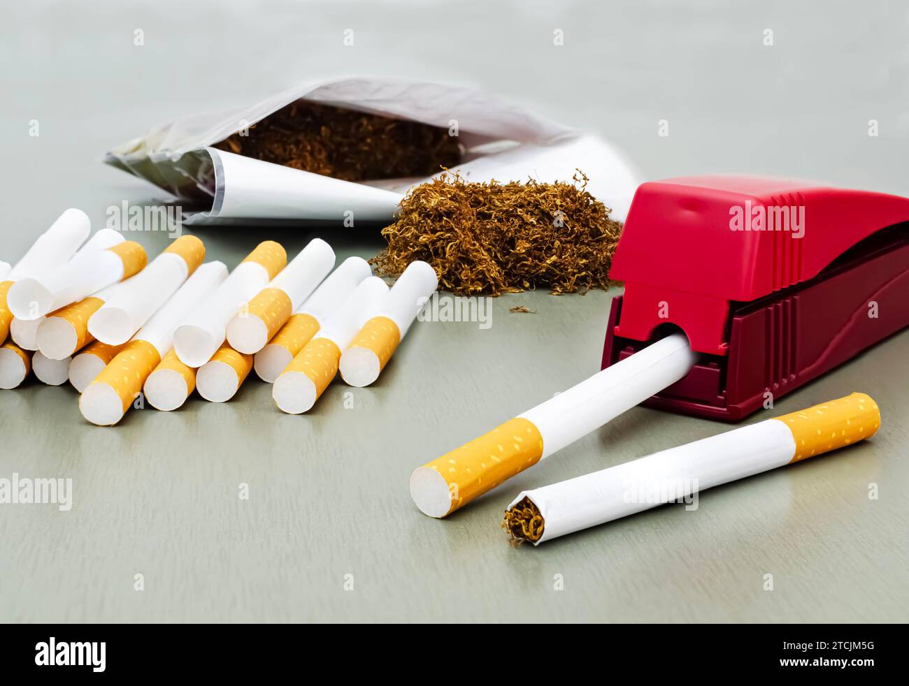 Close-up of a machine for filling empty cigarette tubes with tobacco ...