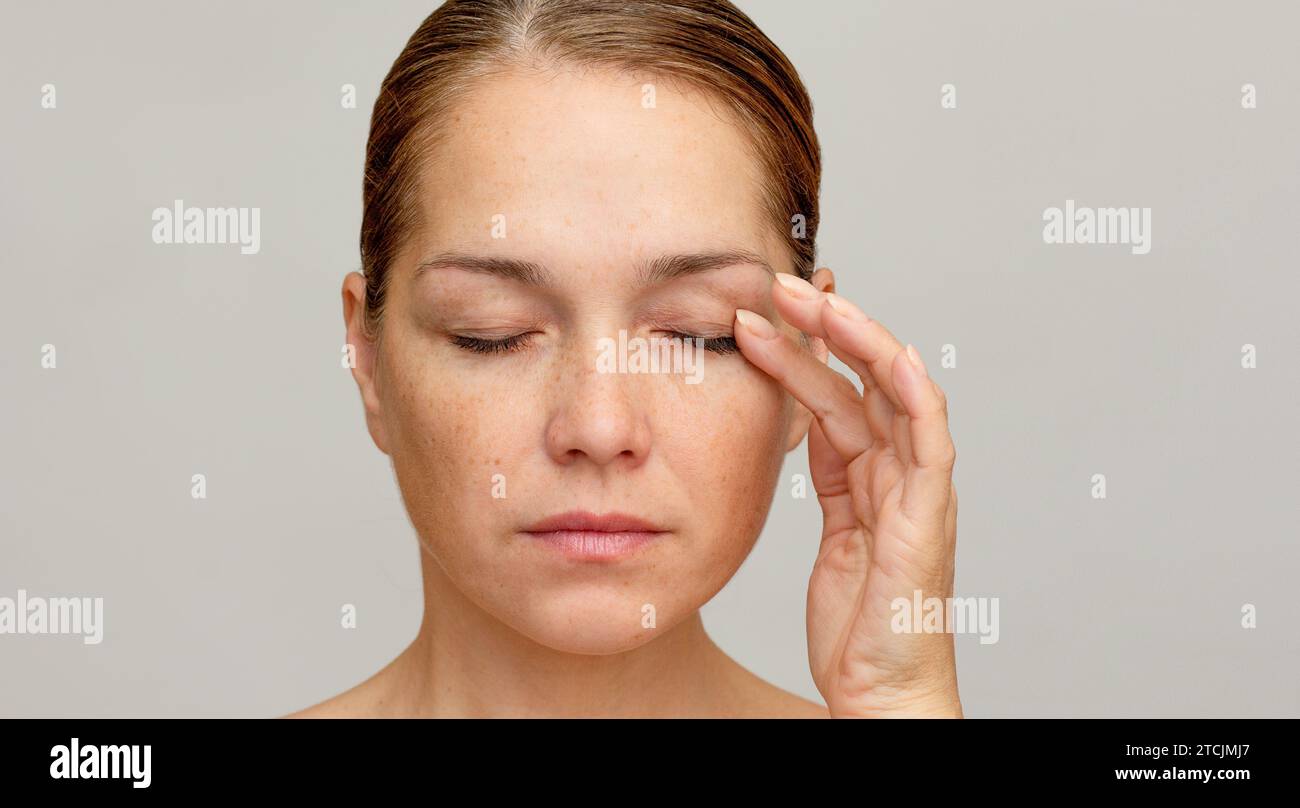 Middle aged caucasian woman of 40s with closed eyes holding finger on ...