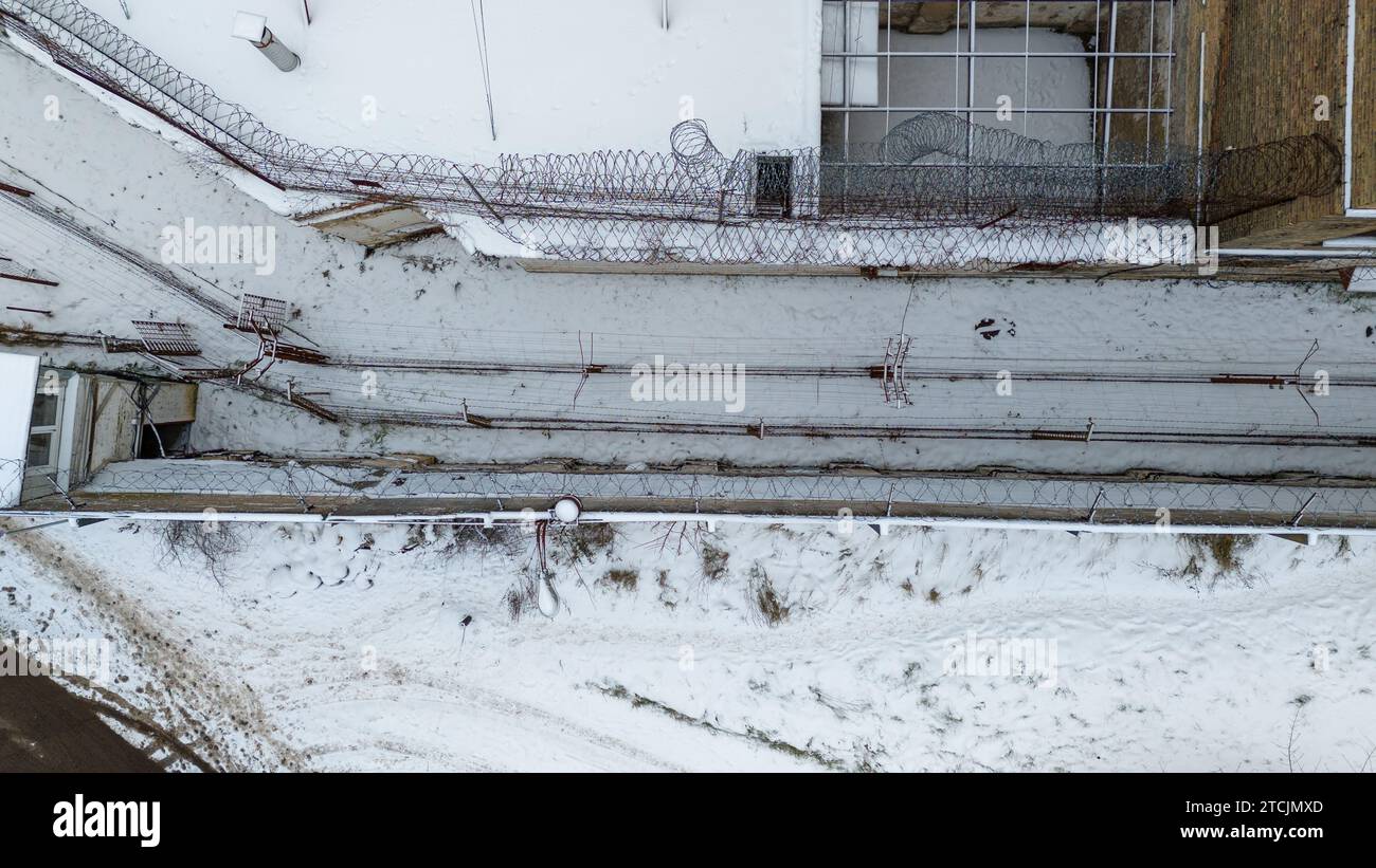 Drone photography of old prison metal and brick fence during winter day ...