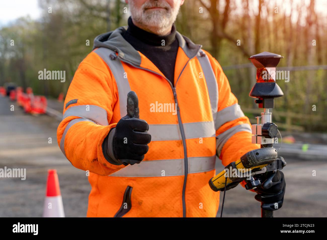 Site engineer operating his instrument during roadworks. Builder using ...