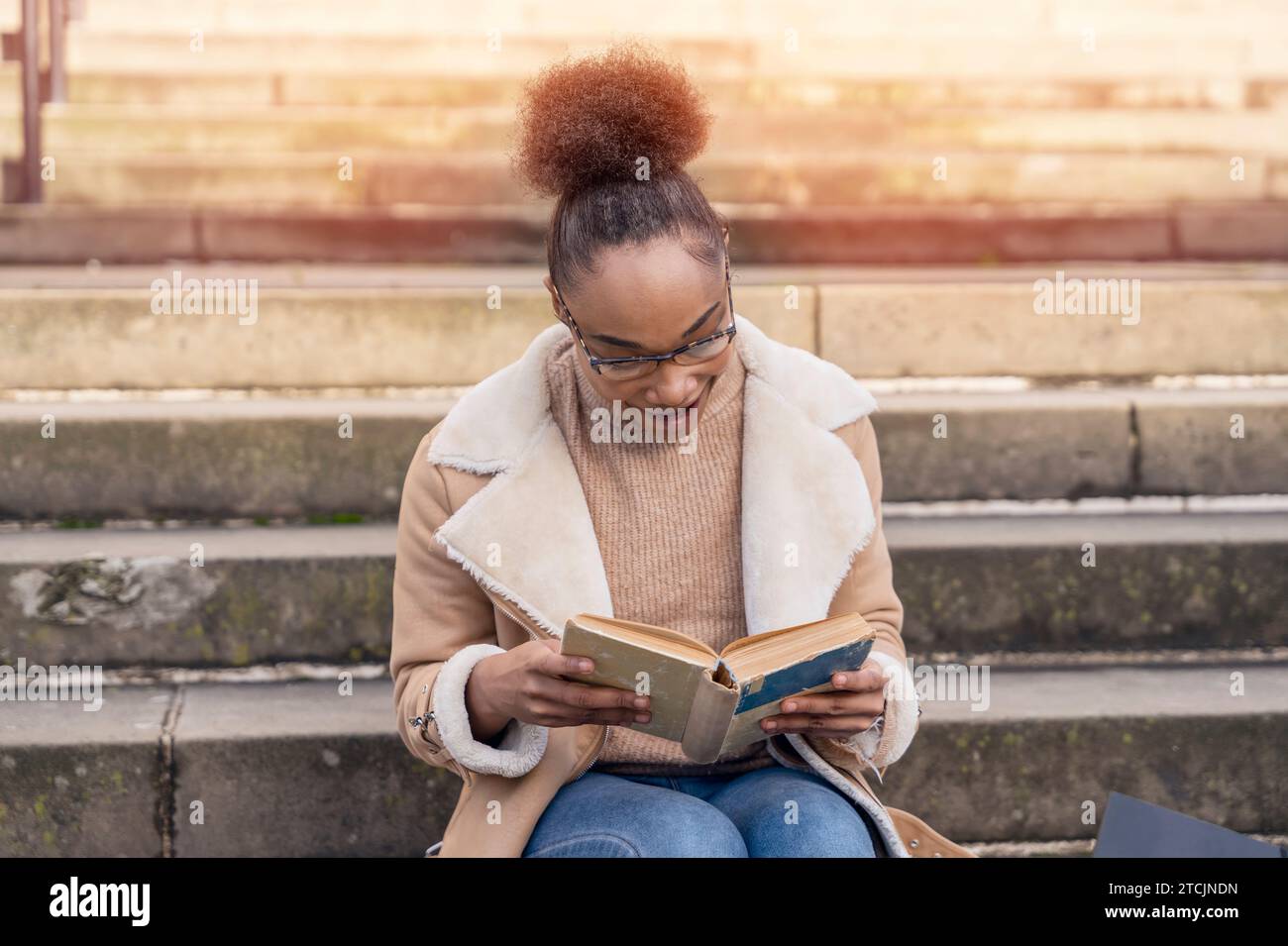 woman student reading a book, making a plan on stairs in city concept ...