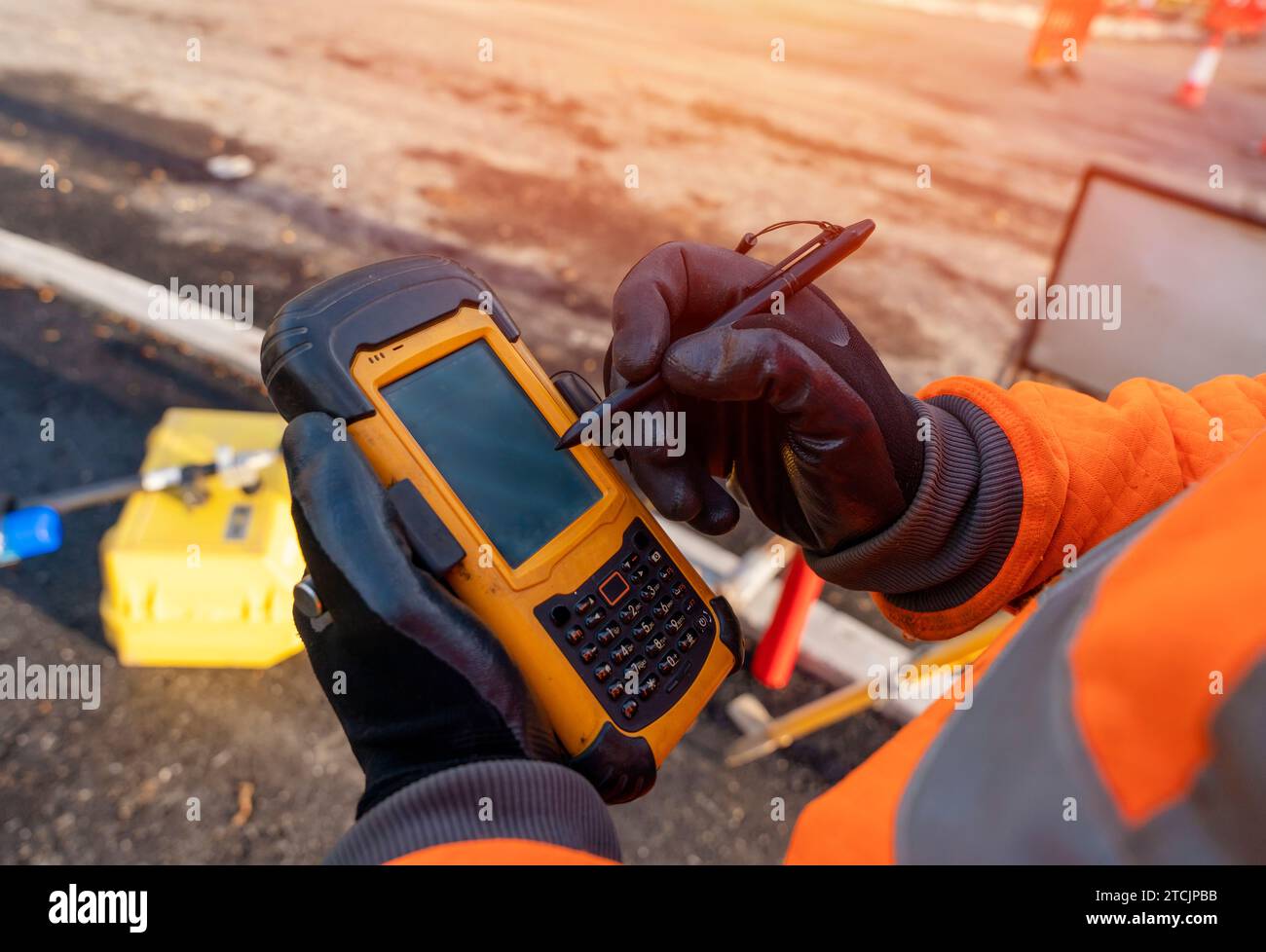 Site engineer operating his instrument during roadworks. Builder using ...