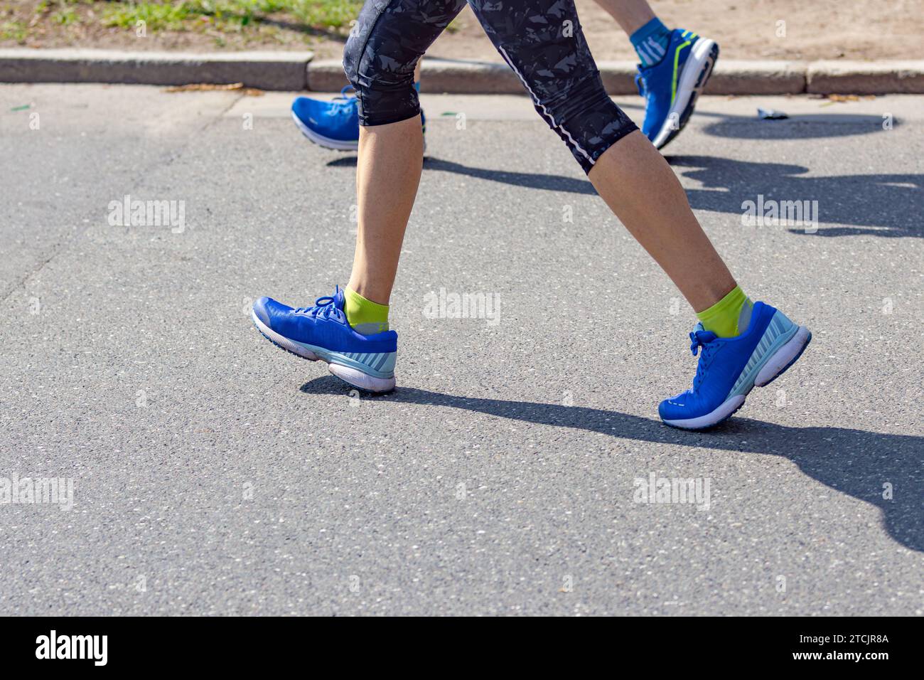 Female marathon runner with blue running shoes on the asphalt Stock ...