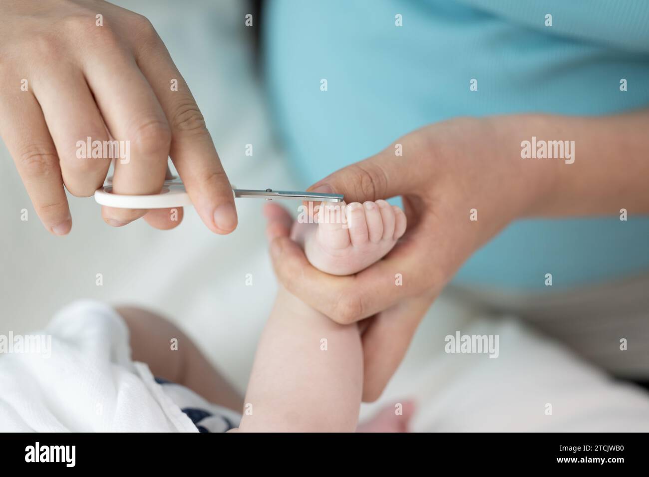 Mother's hands cutting newborn baby's toenails with scissors Stock ...