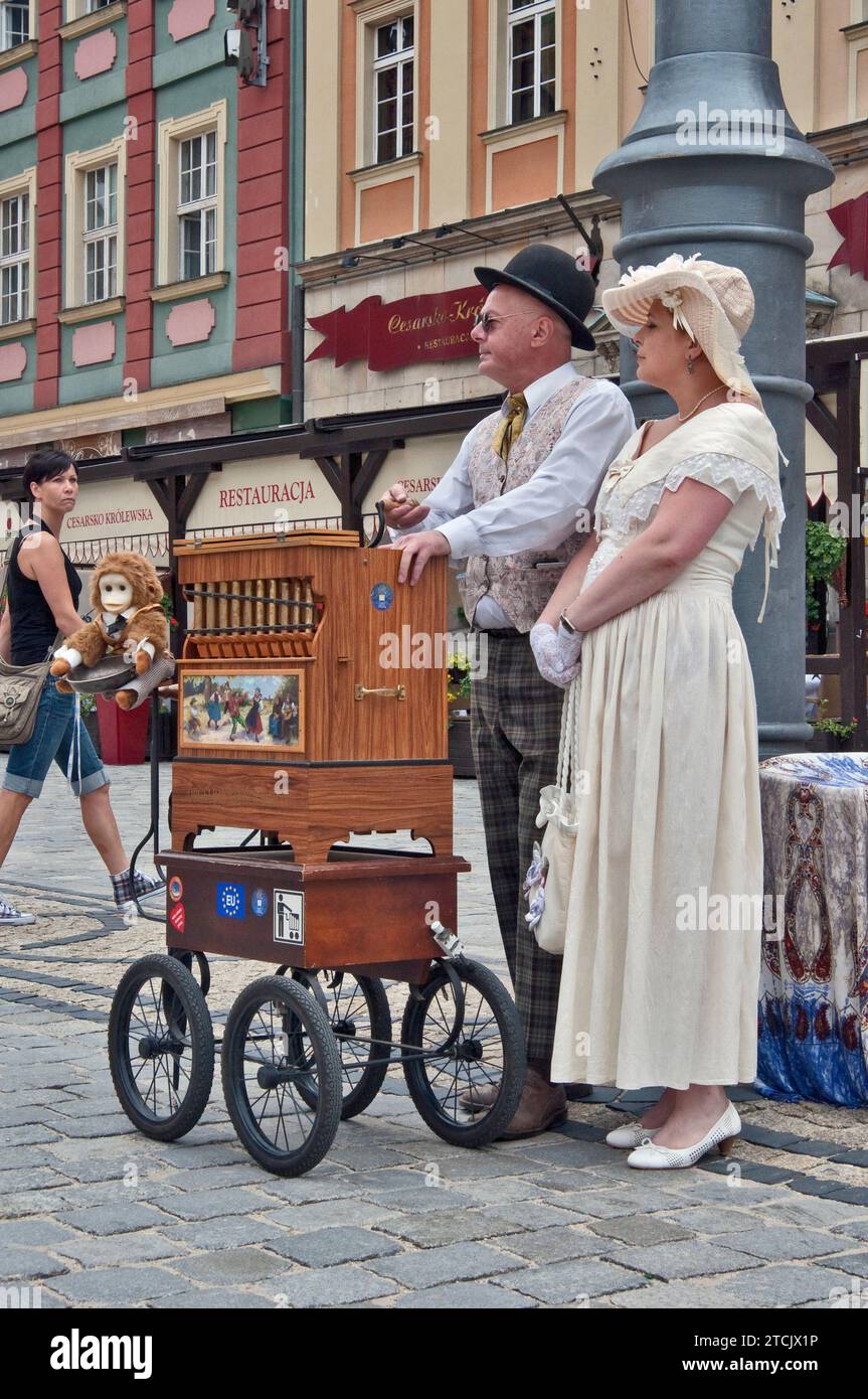 Street organ grinder and woman in costumes at Rynek (Market Square) in ...