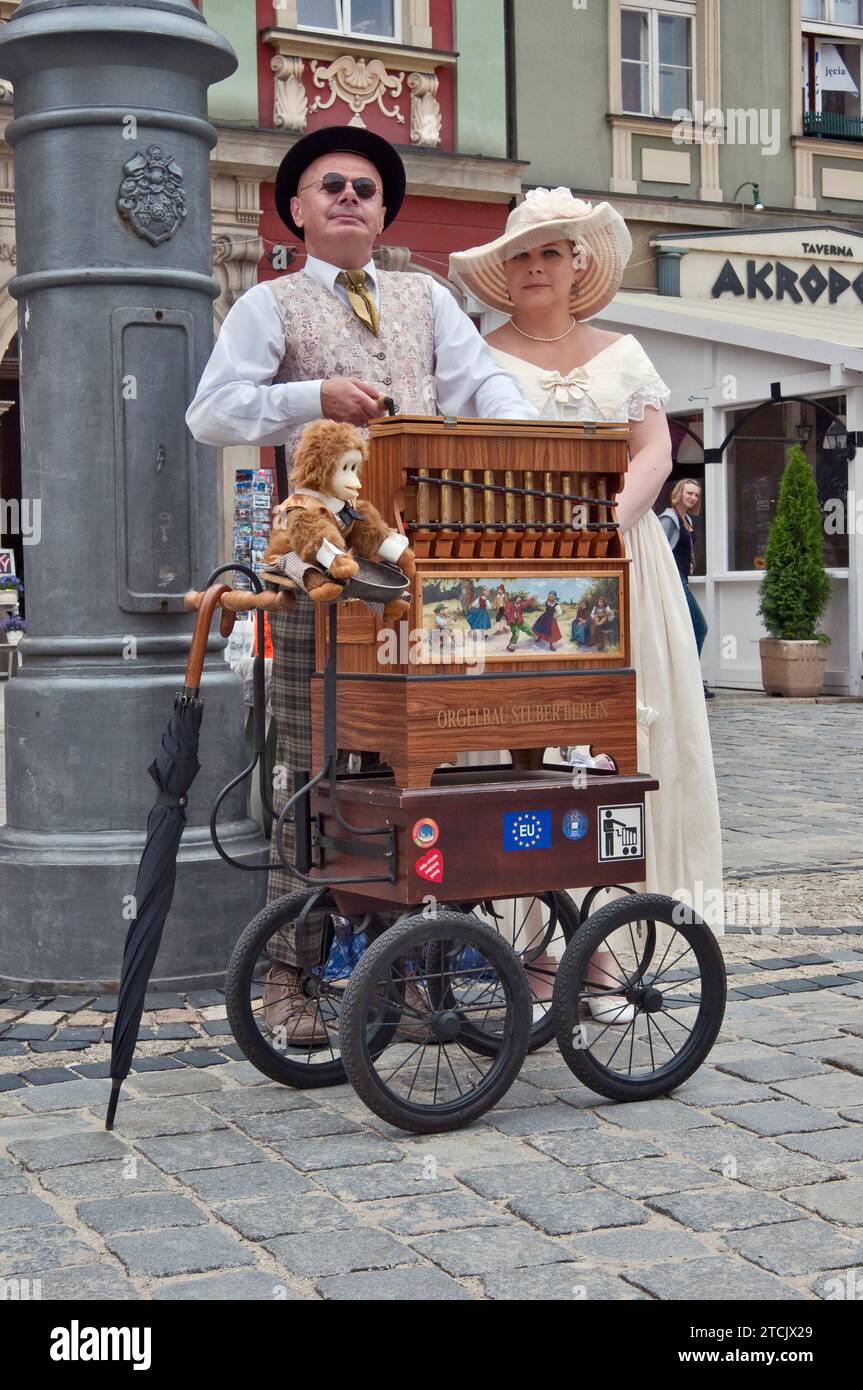 Street organ grinder and woman in costumes at Rynek (Market Square) in ...