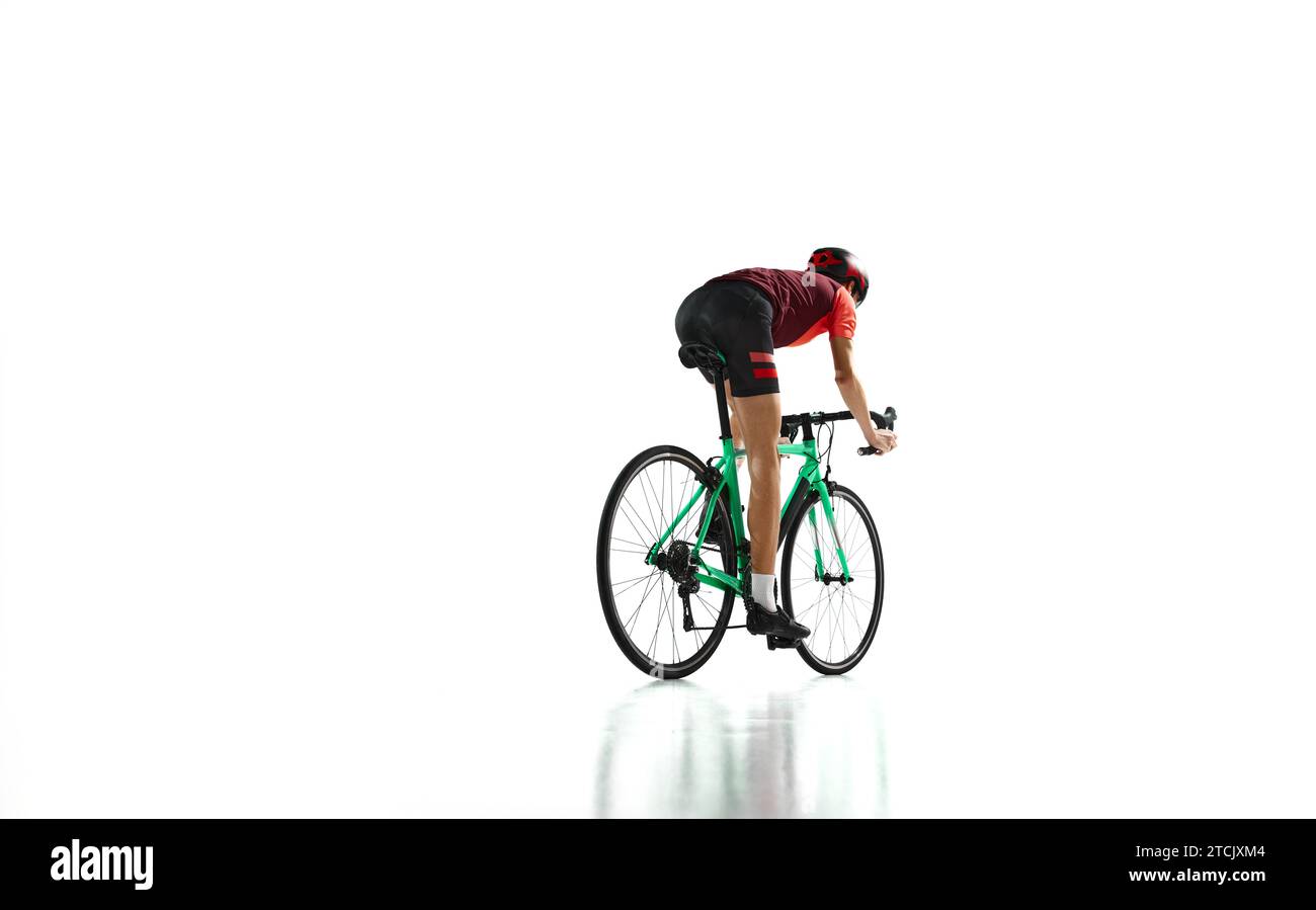 Back view. Young man, cyclist in sportswear and helmet riding bicycle ...
