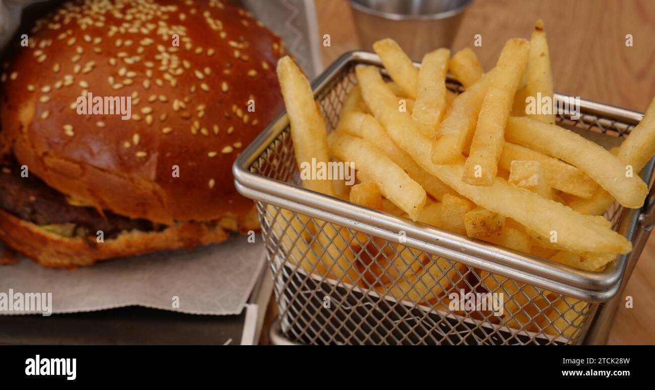 Serving a fast menu of beef burger and french fries in a special basket ...