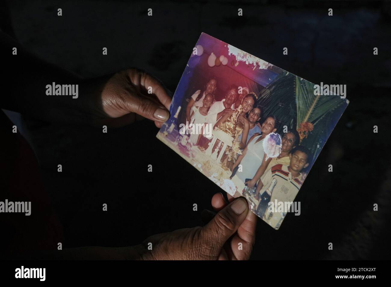 Guadalupe Cobos holds a 20-year-old family photograph, inside her home ...