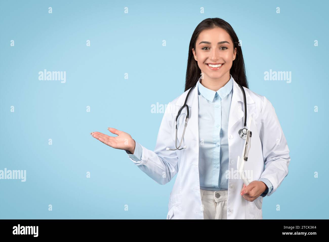 Happy young woman doctor presenting with an open hand gesture Stock ...