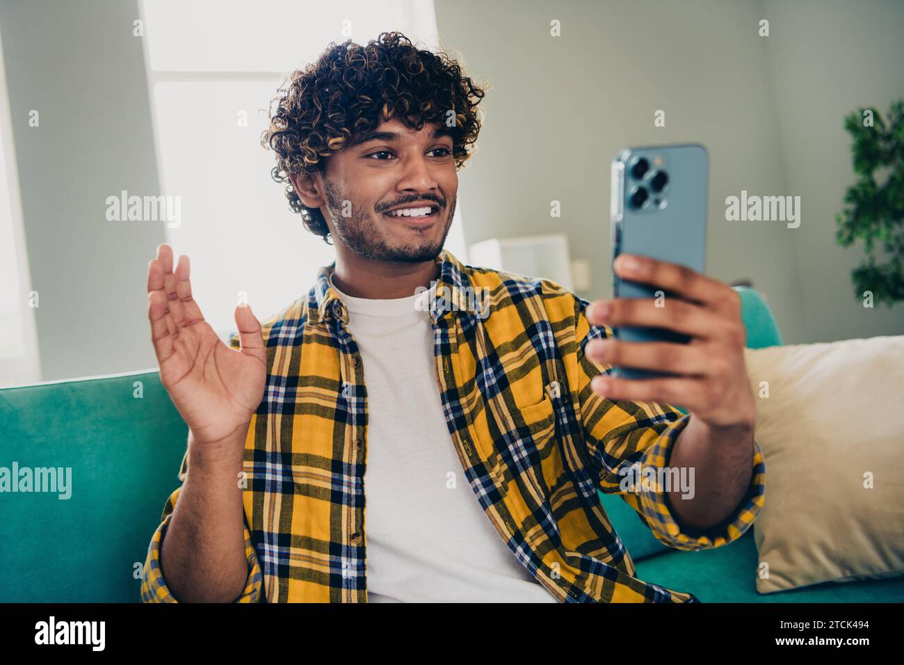 Portrait of nice positive person sit couch hold smart phone take selfie ...