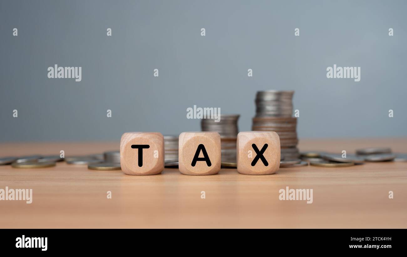 Tax wording print screen on wooden cube block and coins stacking for ...
