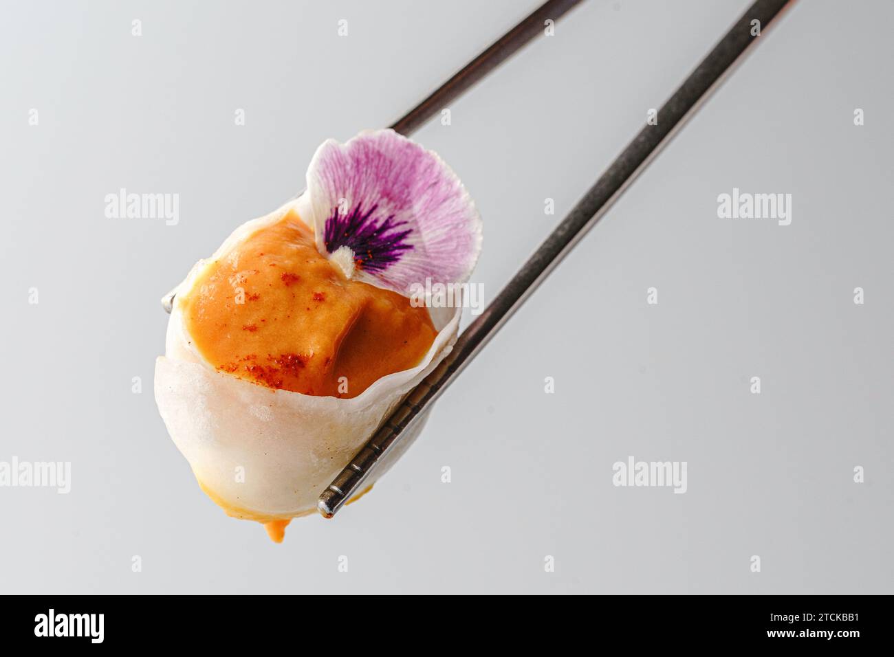 A delicate dim sum dumpling filled with savory contents, gently held by ...