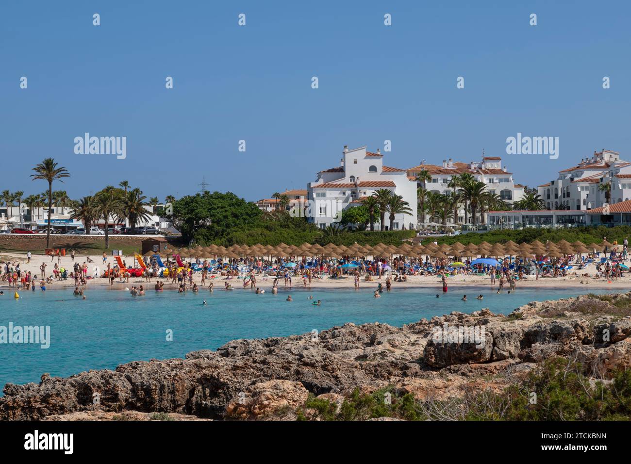 Tourists enjoy the sea water in the resort of Cala en Bosc on the ...