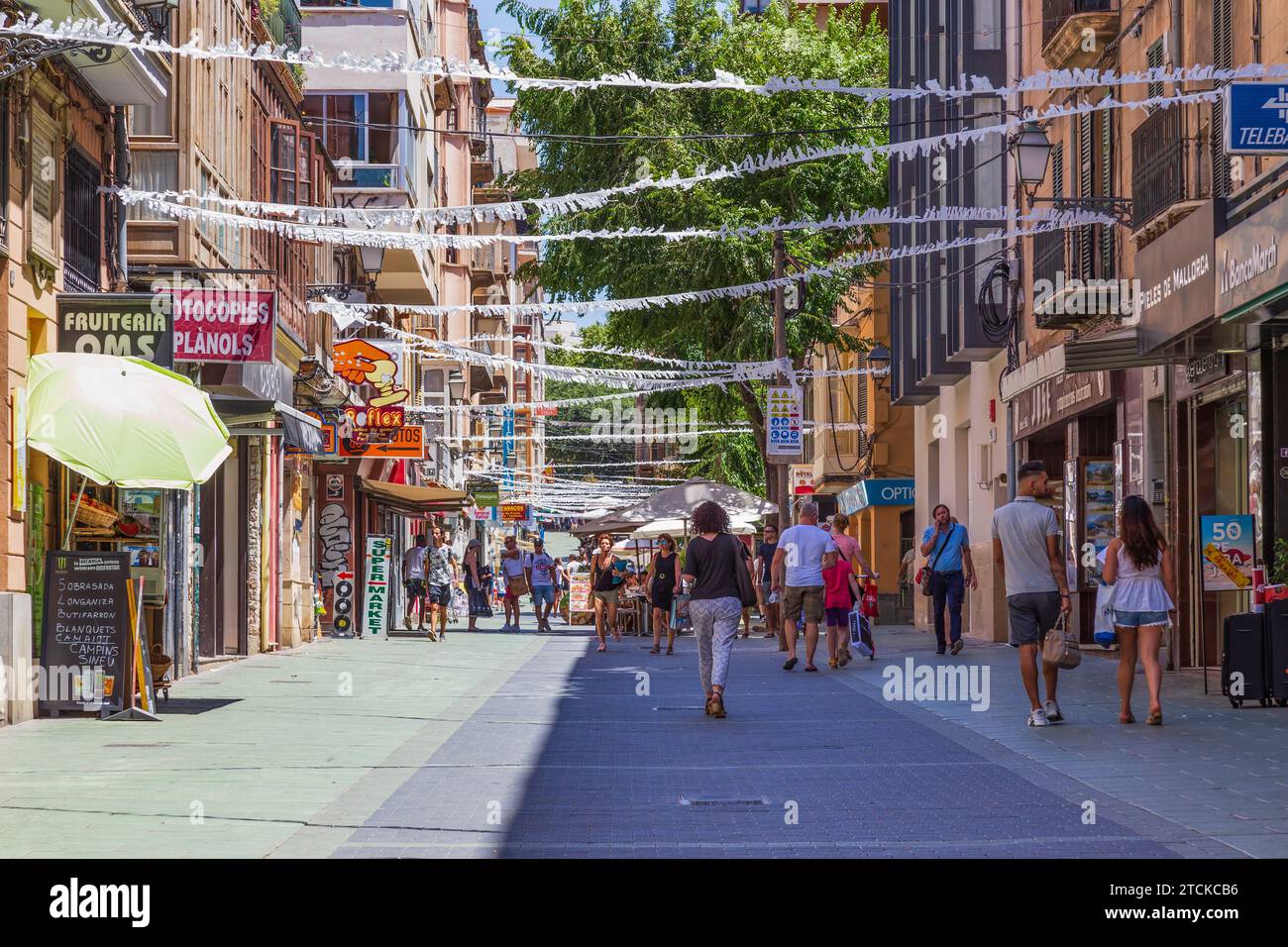 People walk through a pleasant shopping street in Palma de Mallorca ...