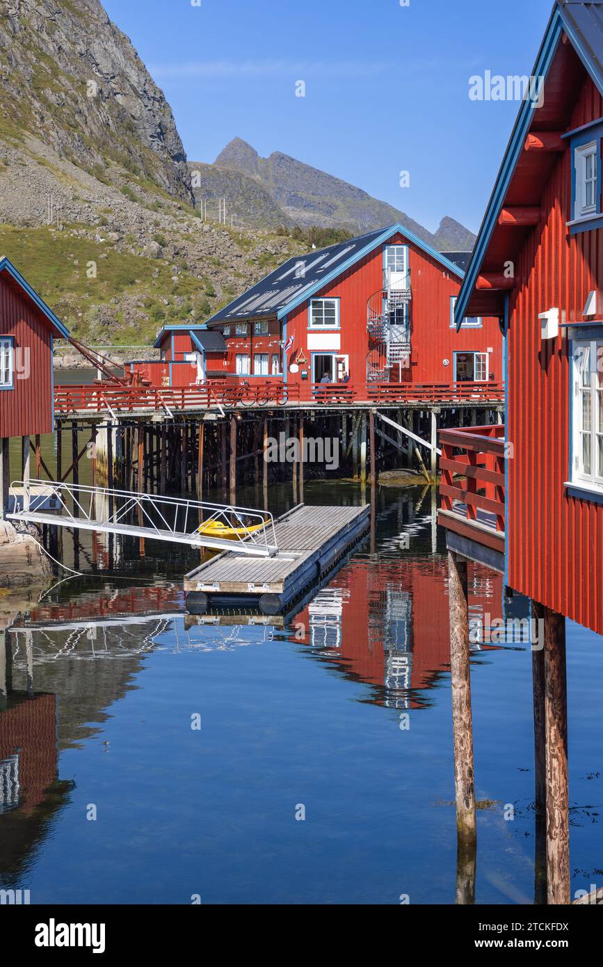 Vertical photo showcasing classic red Rorbu fishing huts on stilts ...