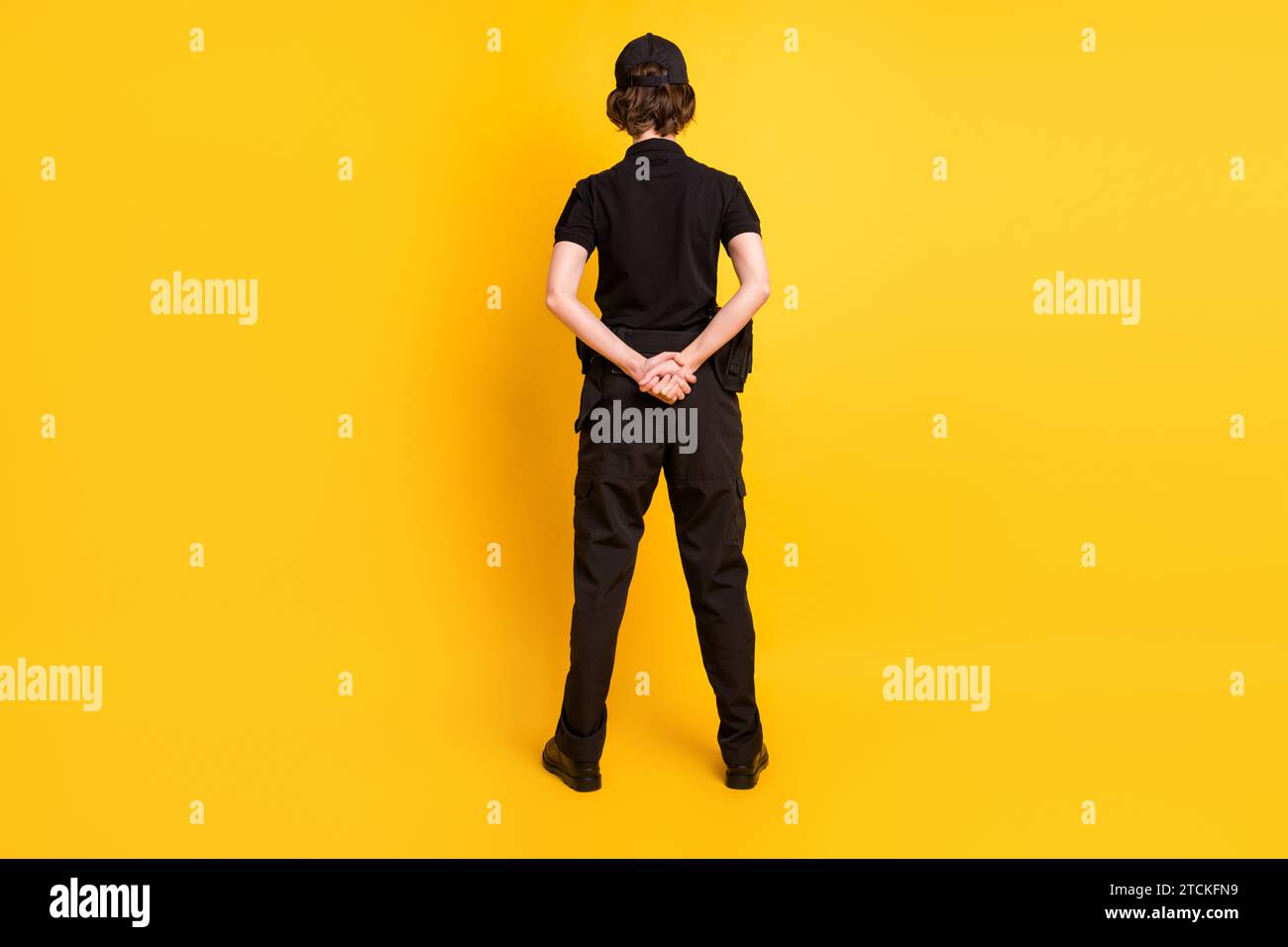 Full body rear photo of police girl standing hold hands behind back ...