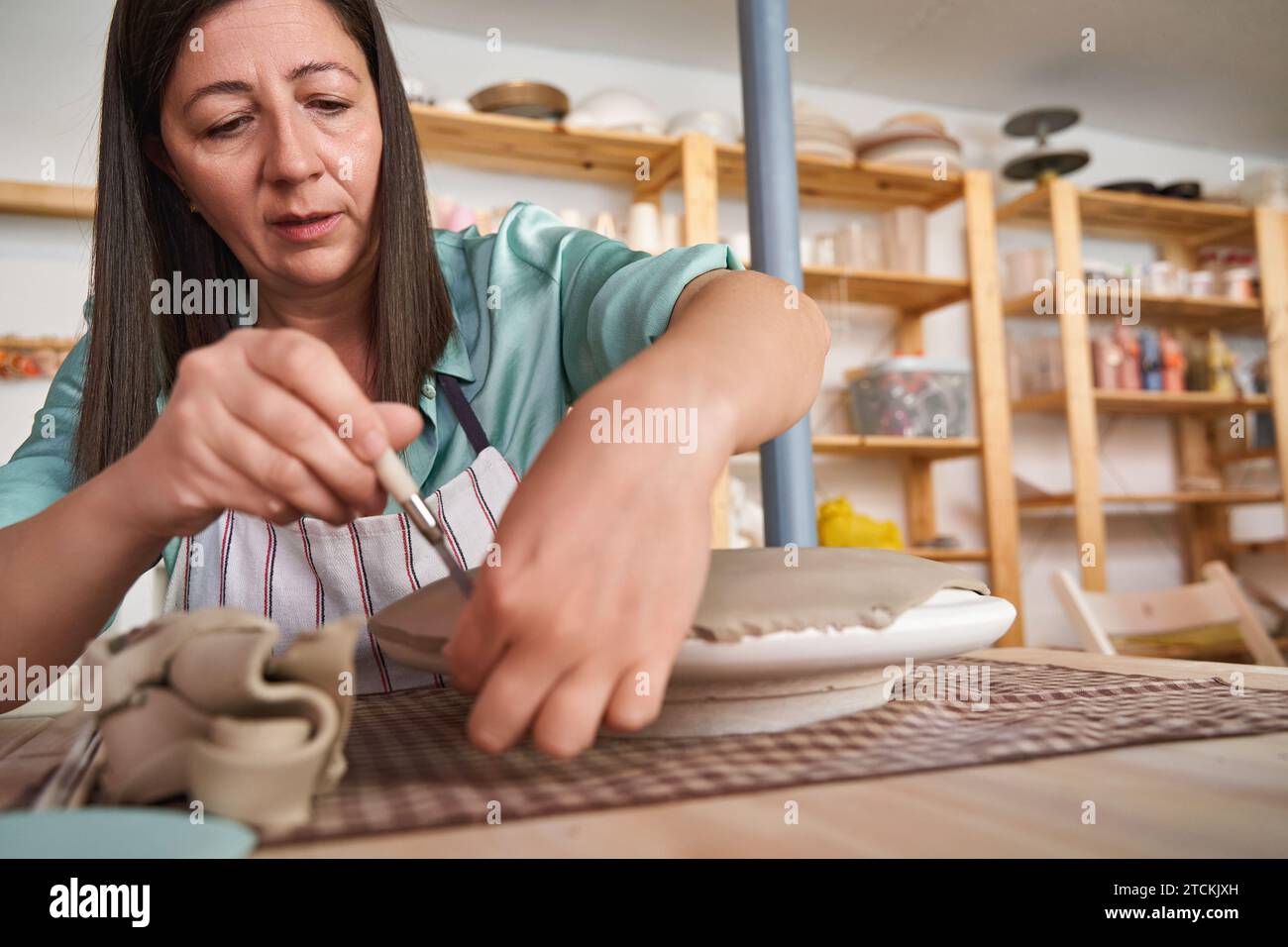 Dedicated ceramist perfecting her work in clay, immersed in the ...