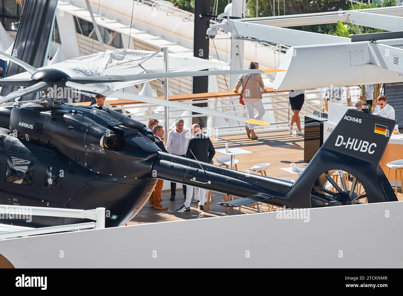 Rich clients visitors examine a helicopter standing on the deck of a yacht club, the largest ...